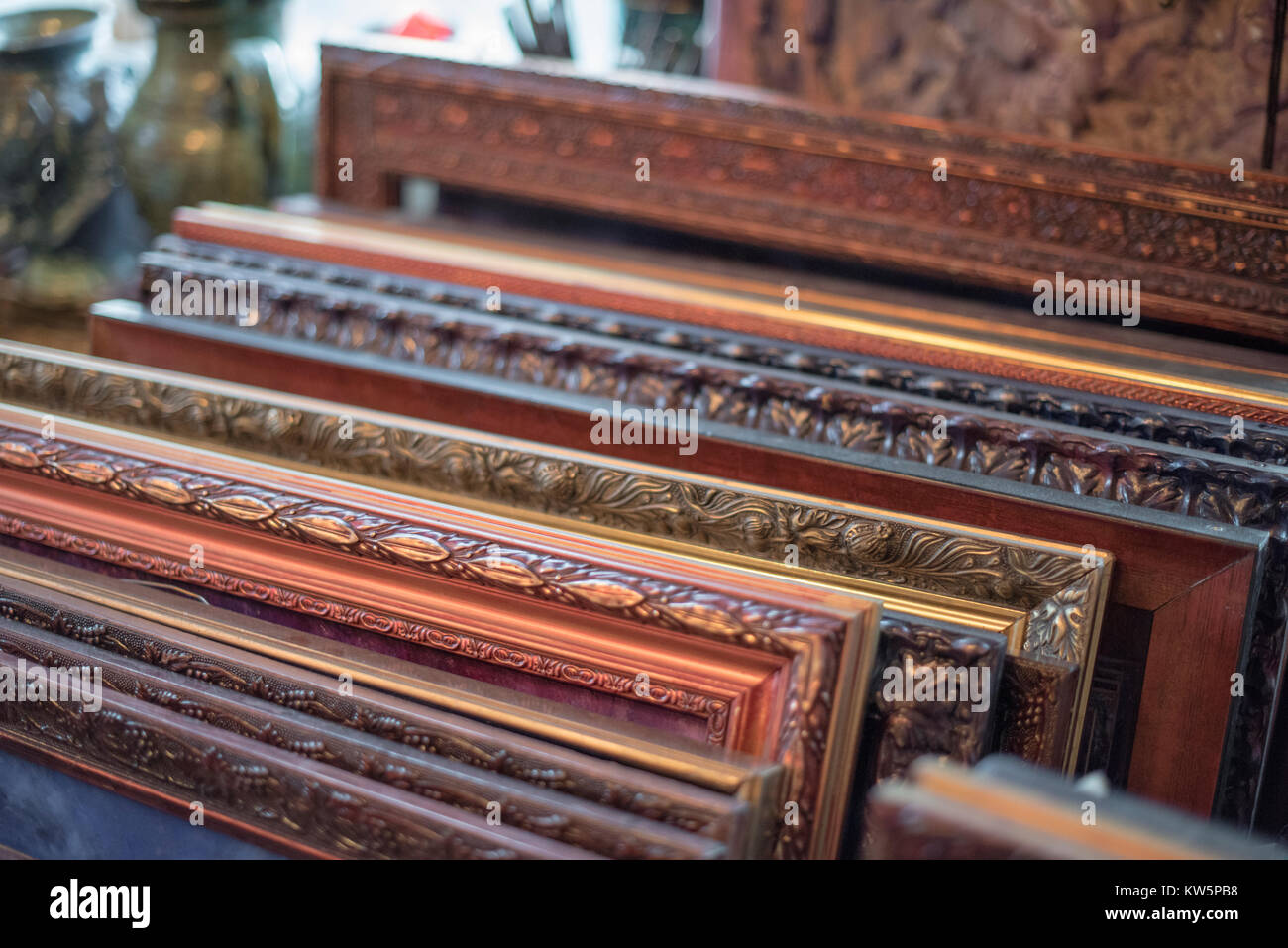 A stack of painting frames, 15 in total, in various shades of gold and ...