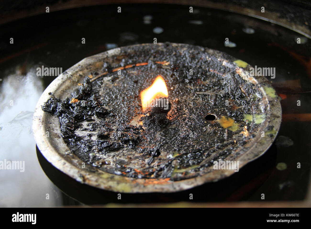 Match with fire on the iron plate in the temple Stock Photo - Alamy