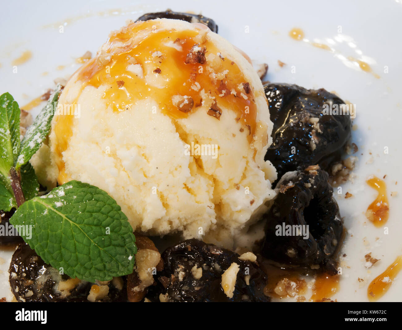 Plums marinated in rum with vanilla ice cream and caramel sauce Stock ...