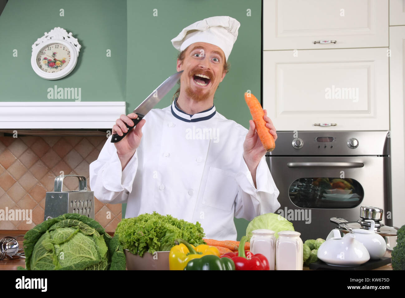 Funny young chef with carrot, preparing lunch in kitchen Stock Photo ...