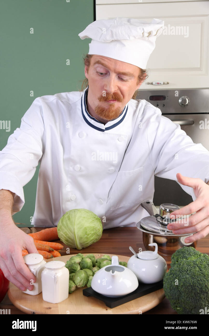 Funny young Chef takes the salt, preparing lunch in kitchen Stock Photo ...
