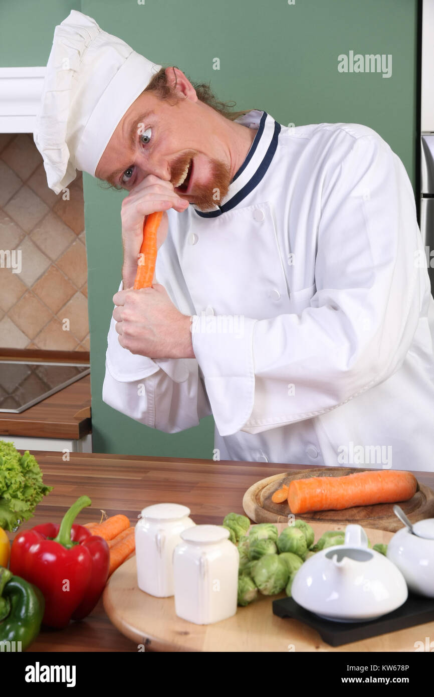 Funny young chef with carrot, preparing lunch in kitchen Stock Photo ...