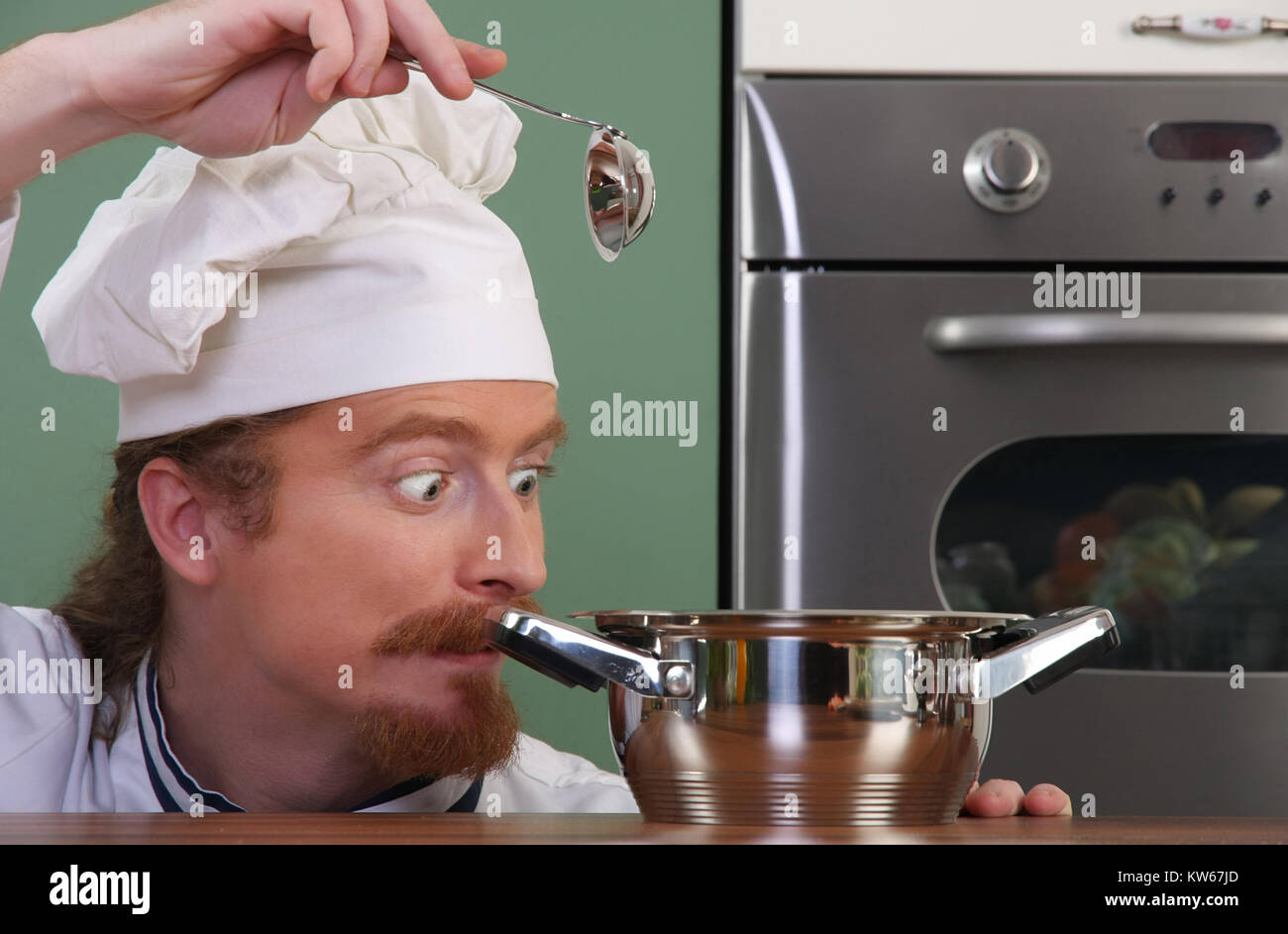Funny young chef strange looking at pot Stock Photo - Alamy