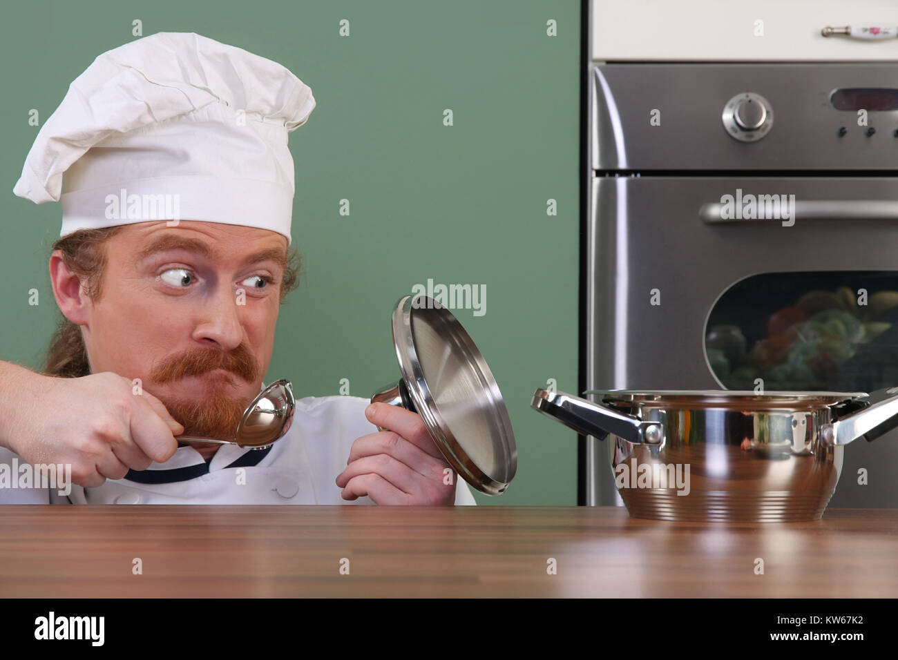 Funny young chef strange looking at pot Stock Photo - Alamy