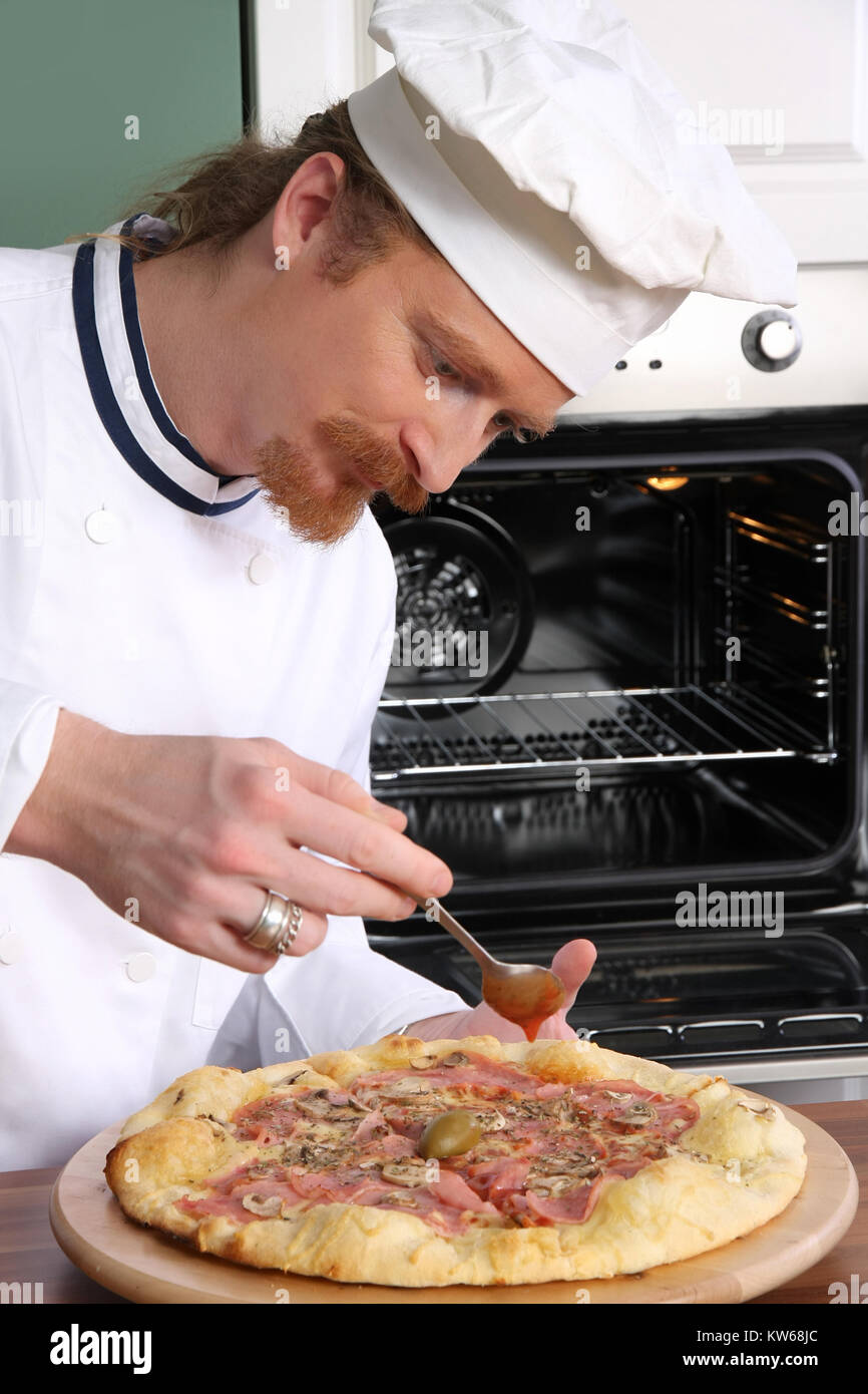 Young chef prepared italian pizza in kitchen Stock Photo - Alamy
