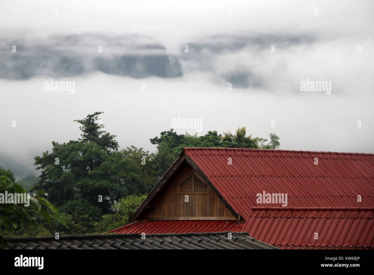Roofs and mountain with clouds in rainy season in Vang Vieng, Laos ...