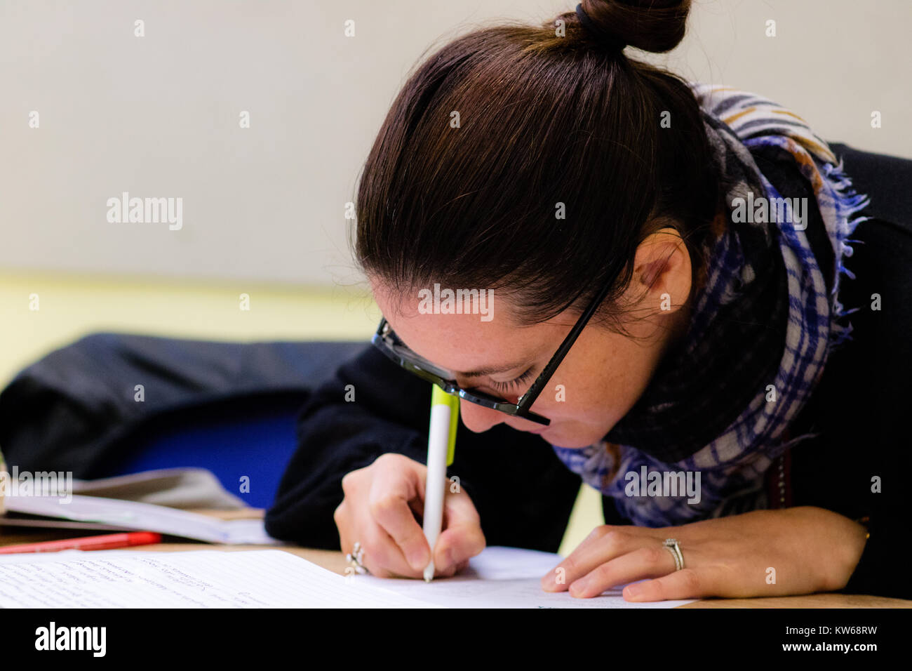 A Lady writing notes at a desk Stock Photo - Alamy