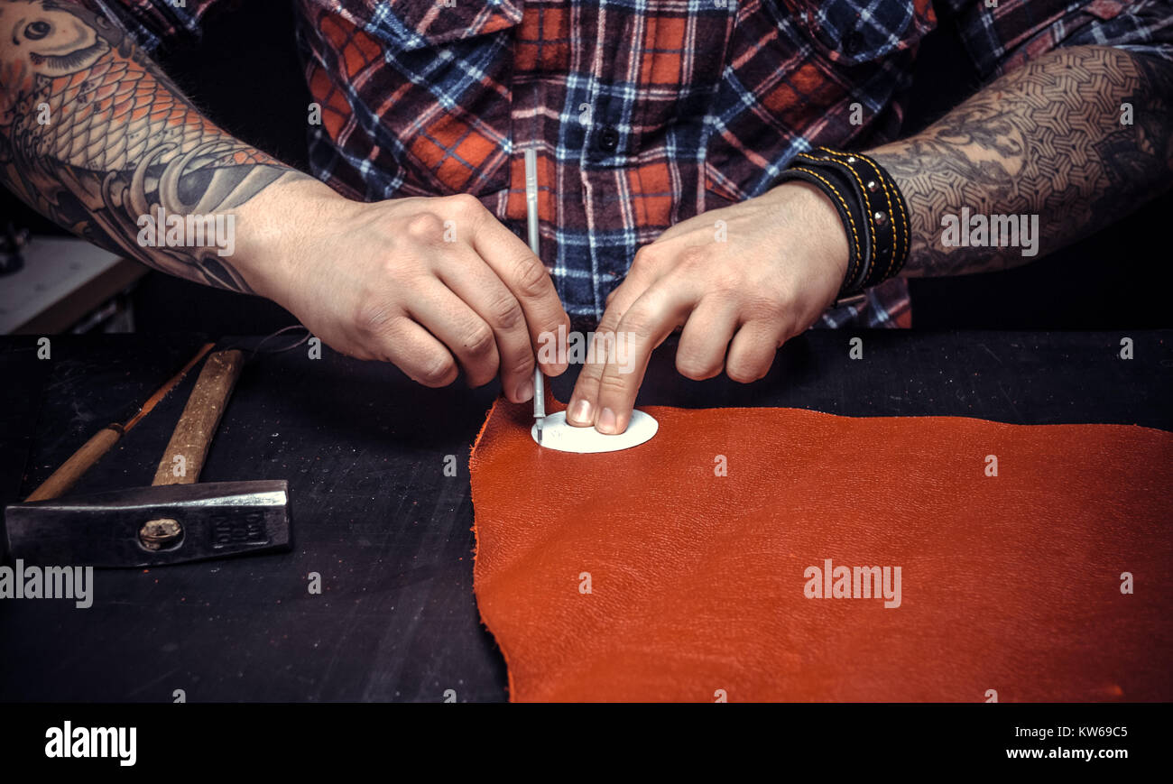 Artist working with leather creating a new leather product Stock Photo ...
