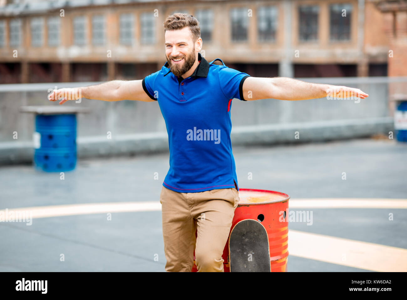 Lifestyle portrait of a handsome man in blue t-shirt flying with hands ...