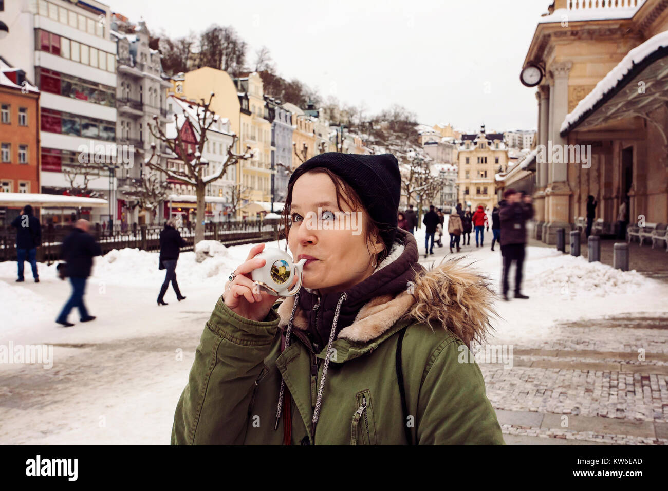 Young woman drinking from cup with therapeutic mineral water at a ...