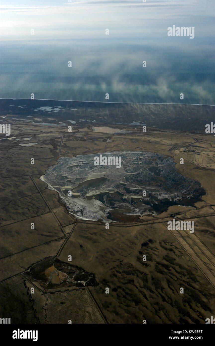 A large frozen lake covered with ice sculptures, surrounded by lava ...