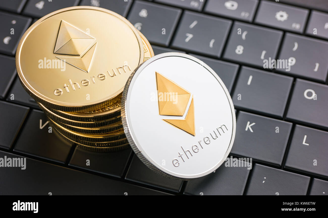 Digital currency physical Ethereum coins on black computer keyboard ...