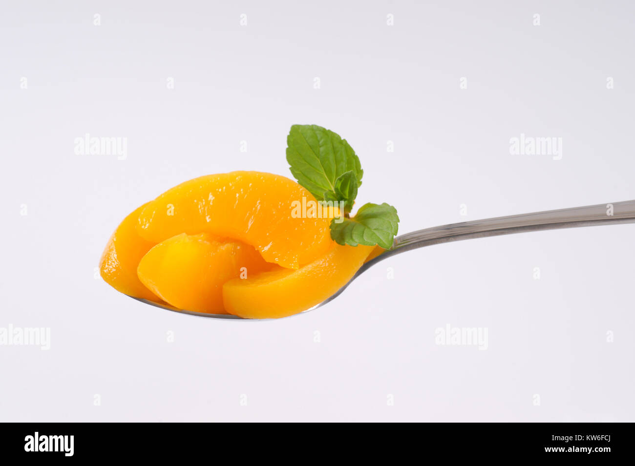 peeled and sliced peaches on silver spoon Stock Photo - Alamy