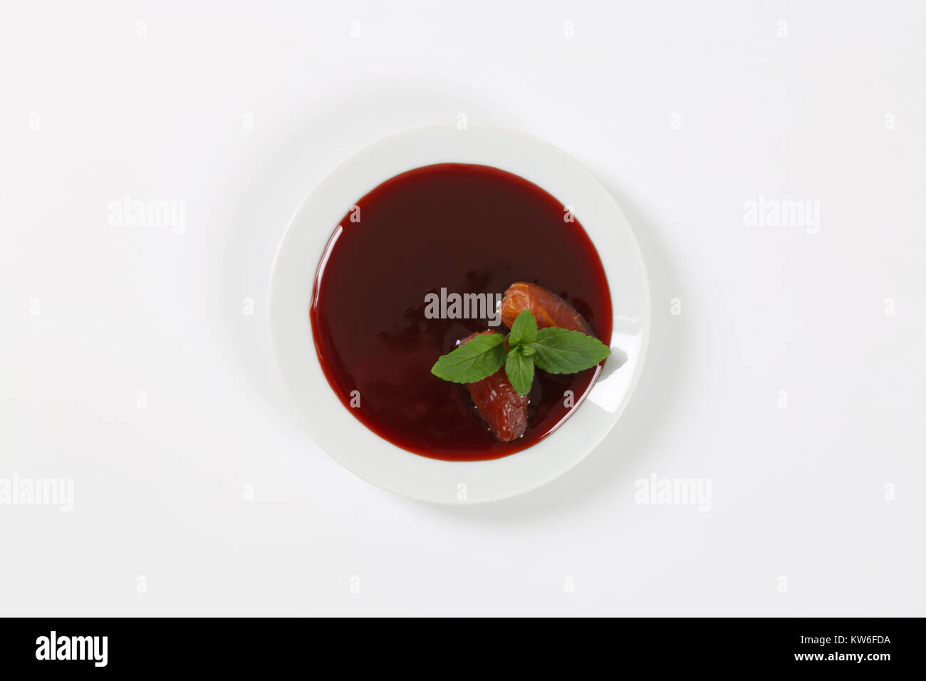 plate of date syrup with dates on white background Stock Photo - Alamy