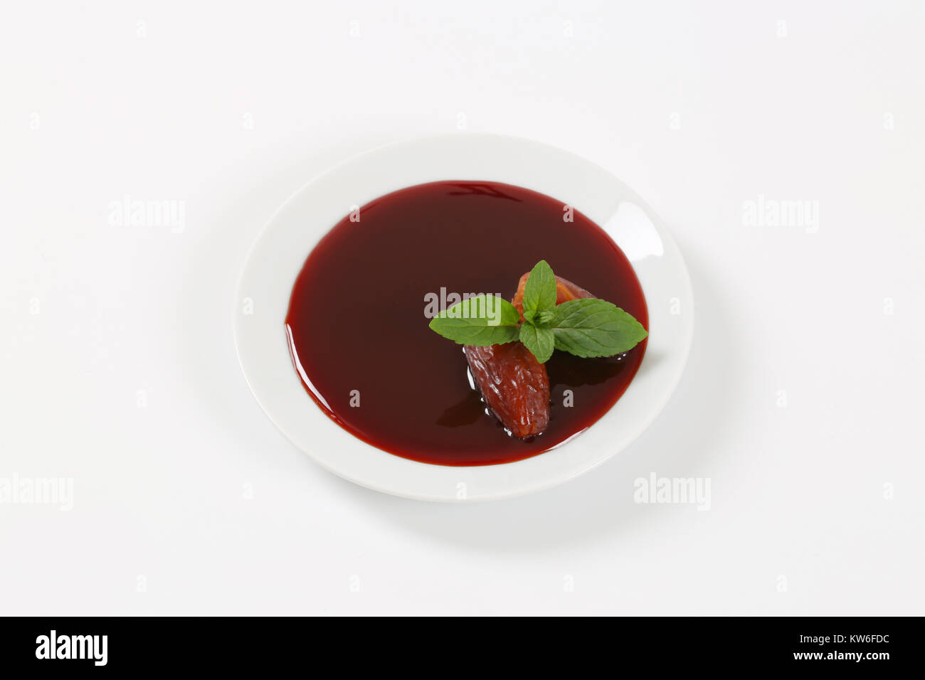 plate of date syrup with dates on white background Stock Photo - Alamy