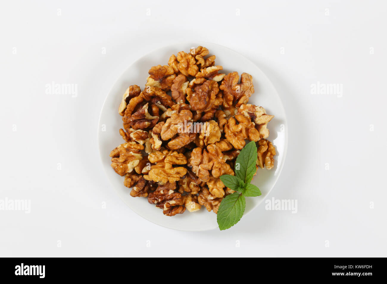 plate of peeled walnuts on white background Stock Photo - Alamy