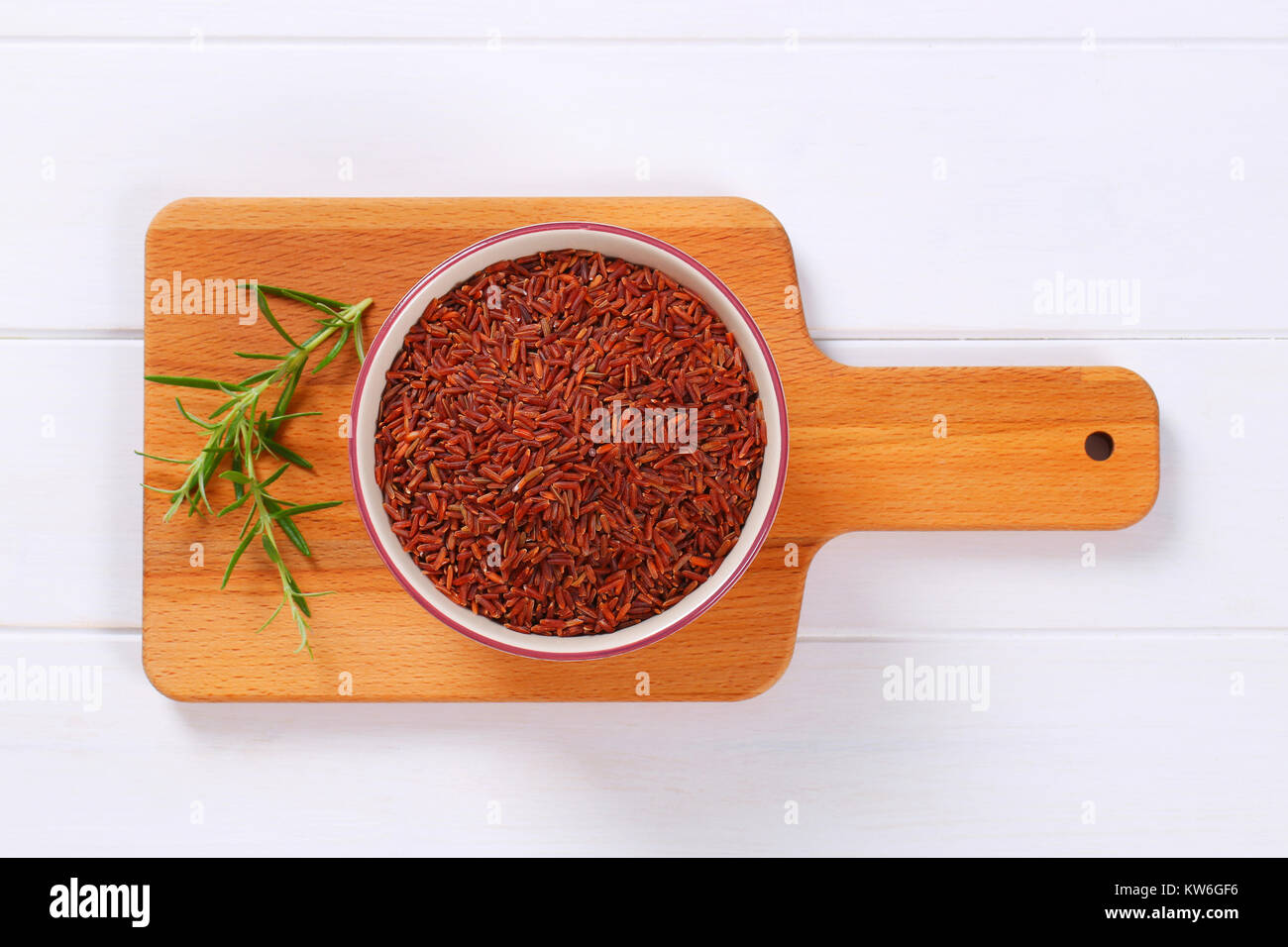 bowl of red rice on wooden cutting board Stock Photo - Alamy