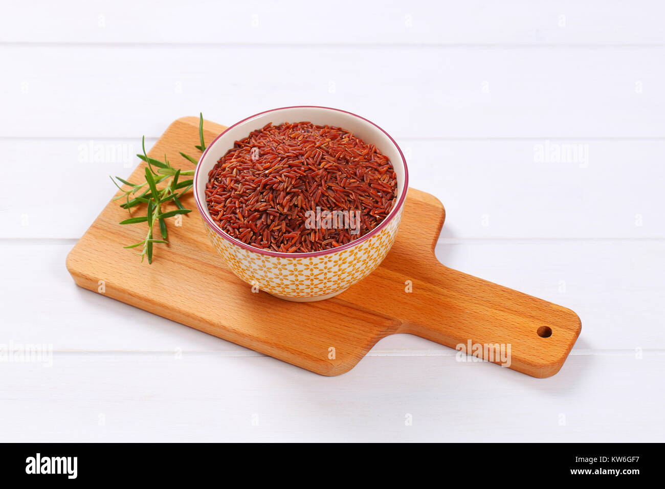 bowl of red rice on wooden cutting board Stock Photo - Alamy
