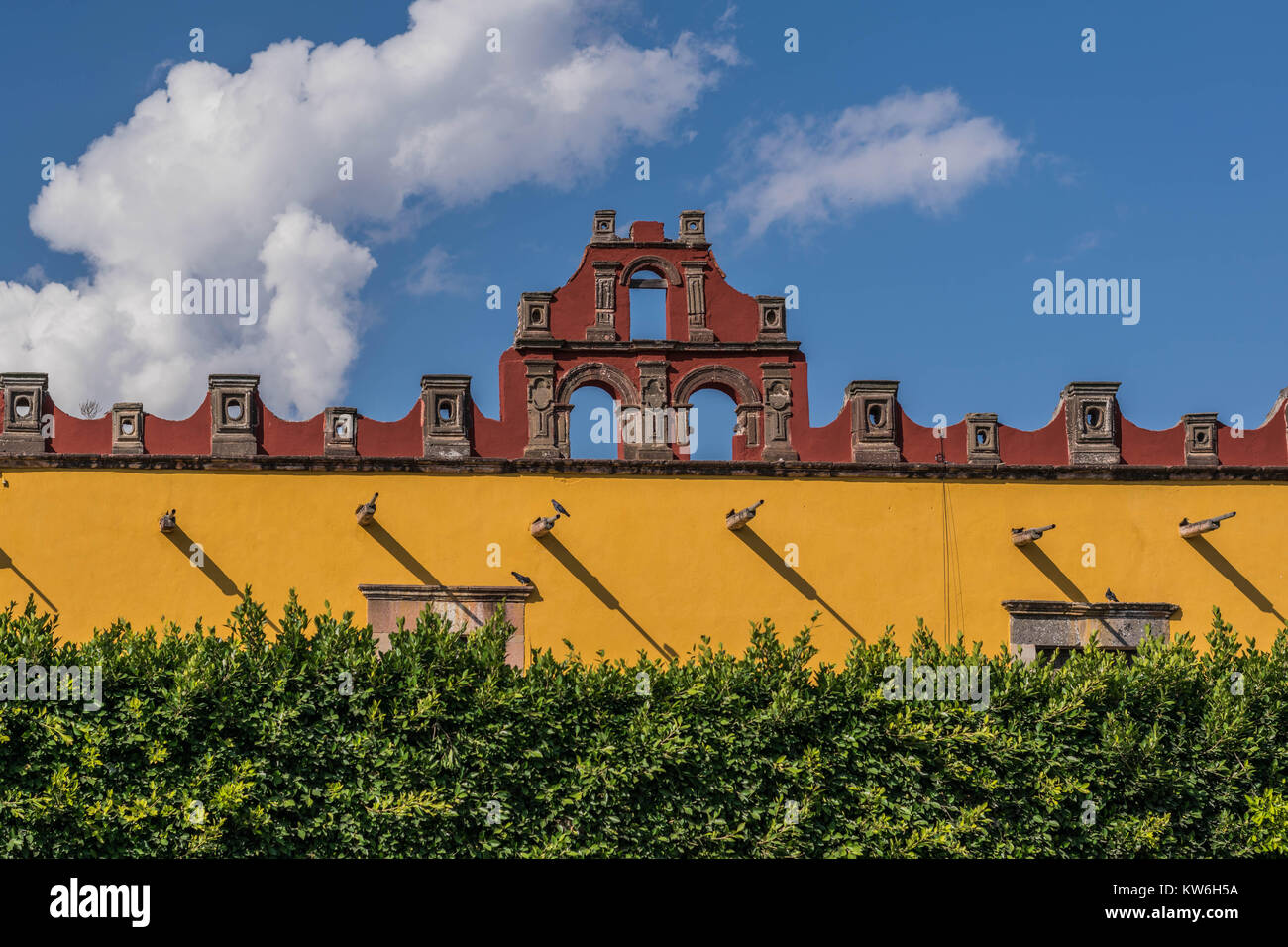 Yellow building with red facade on top with arches and other ...