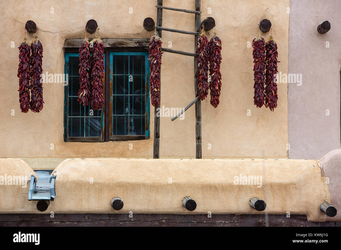 Red chili pepper ristras hanging on adobe buildings, Taos, New Mexico ...