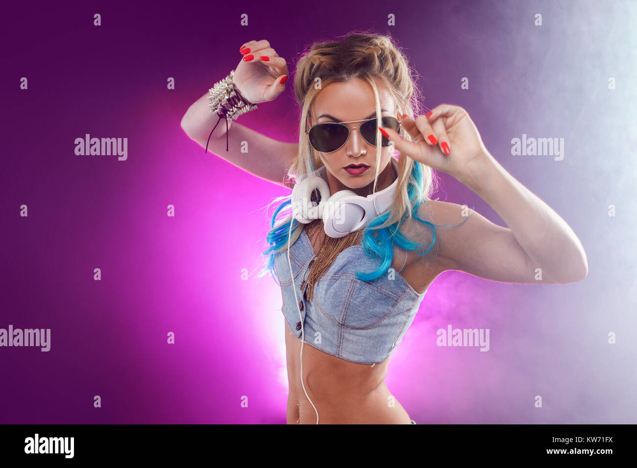 Young fashionable girl in disco style. Listening to music and enjoying ...