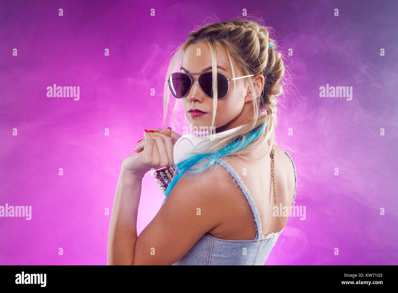 Young fashionable girl in disco style. Listening to music and enjoying ...
