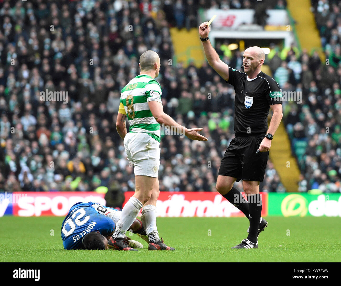 Celtic's Scott Brown is shown a yellow card by referee Bobby Madden ...