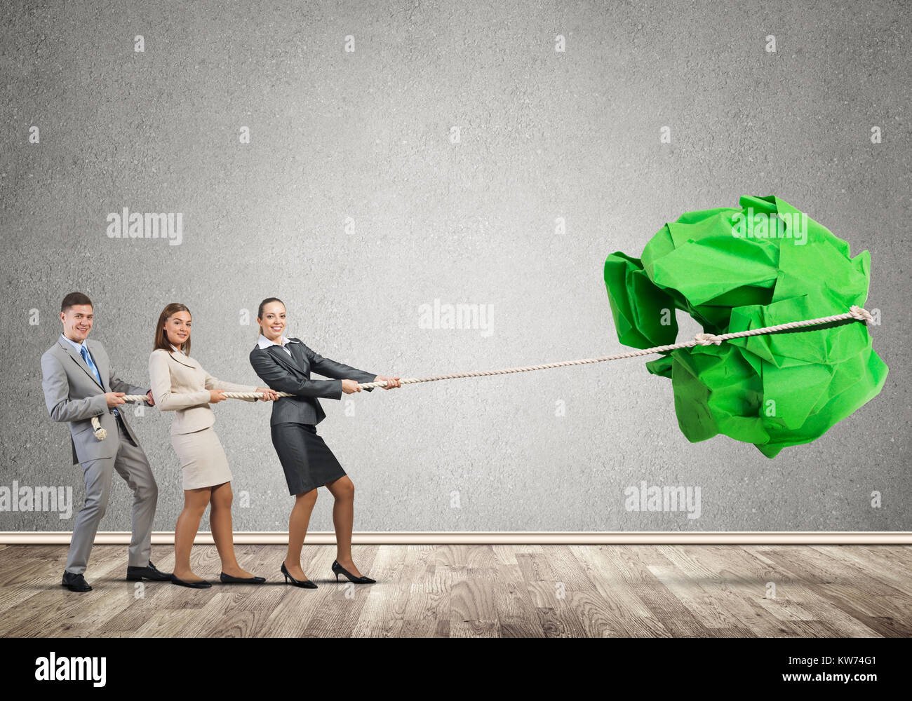 Office employees pulling together big crumpled paper ball Stock Photo ...