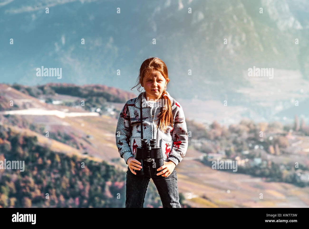 Cute little girl investigating Alps mountains using binocular ...