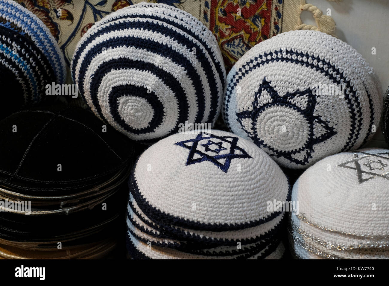 Stack of traditional knitted kippot or yarmulke caps with star of David ...