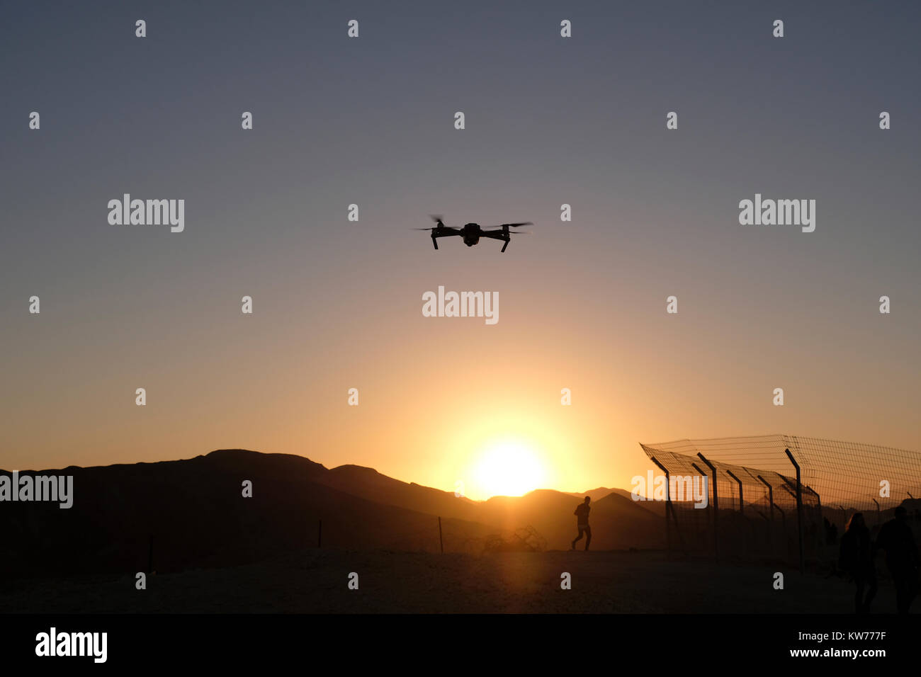A camera equipped radio controlled quadcopter drone flying over an ...