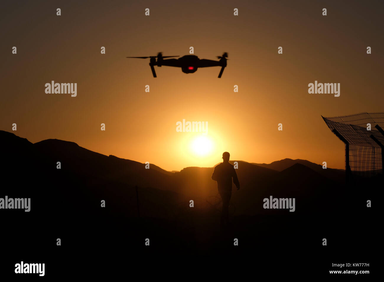 A camera equipped radio controlled quadcopter drone flying over a ...