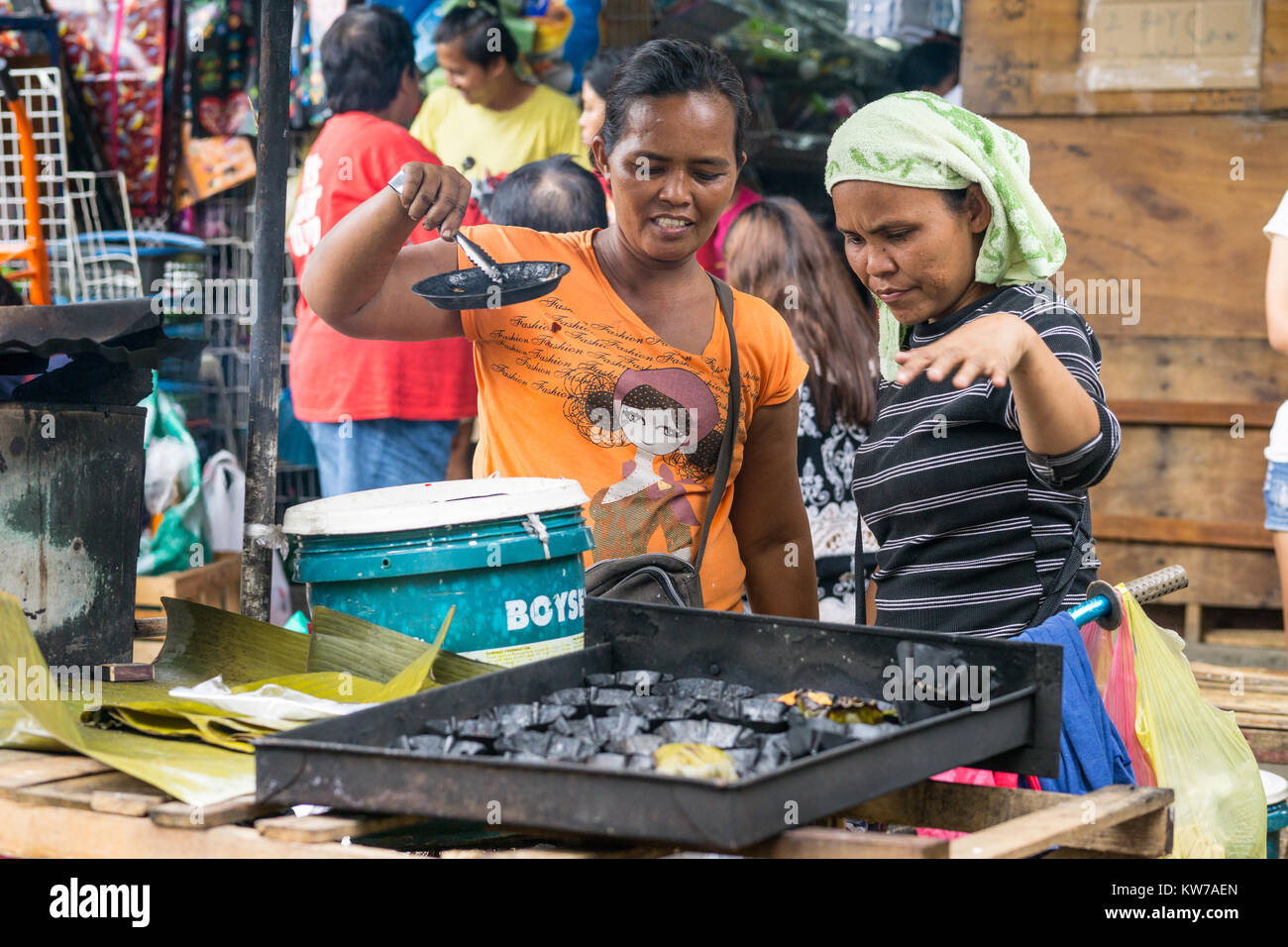 Two women making the Filipino Dessert knwn as Bibingka,downtown Cebu ...