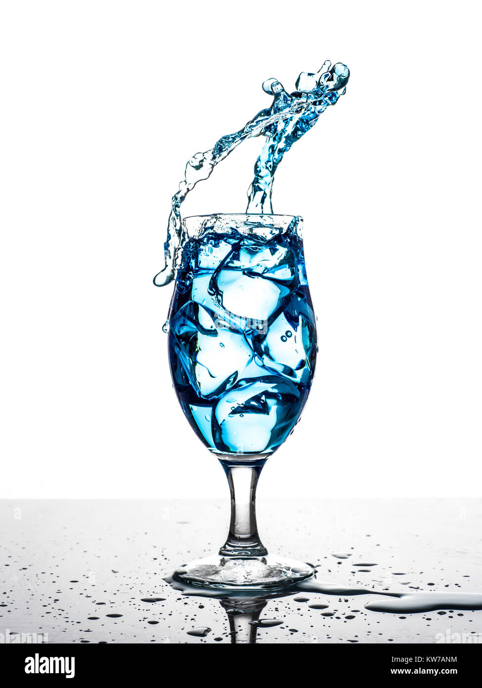 Blue water splash - ice cubes dropped into drinking glass of blue liquid. Splash captured with ...