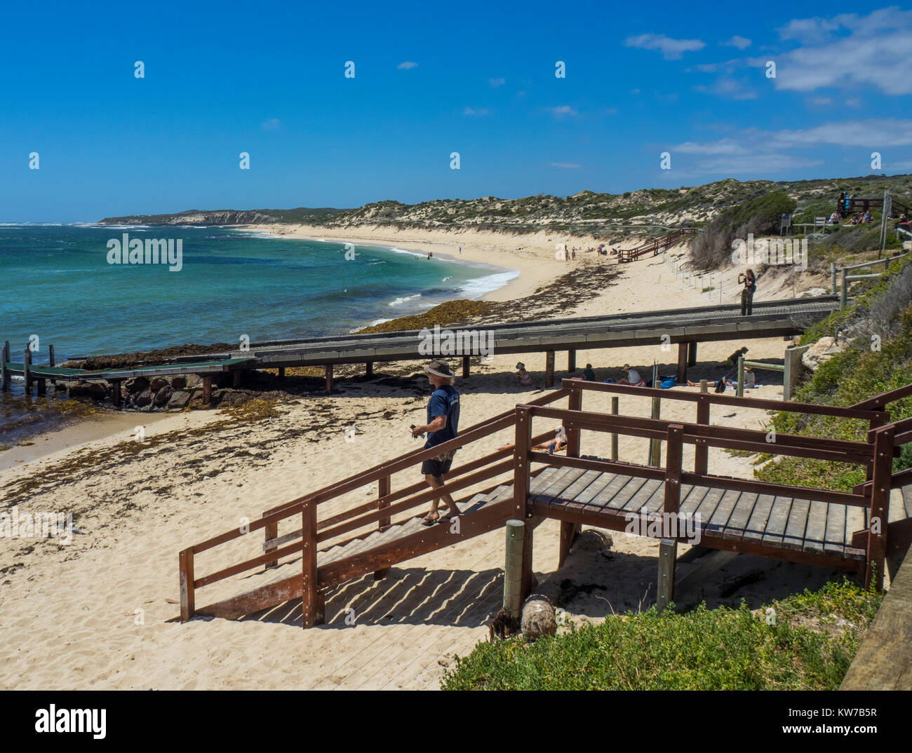 A man walking down wooden steps to the beach at Gnarabup Beach ...