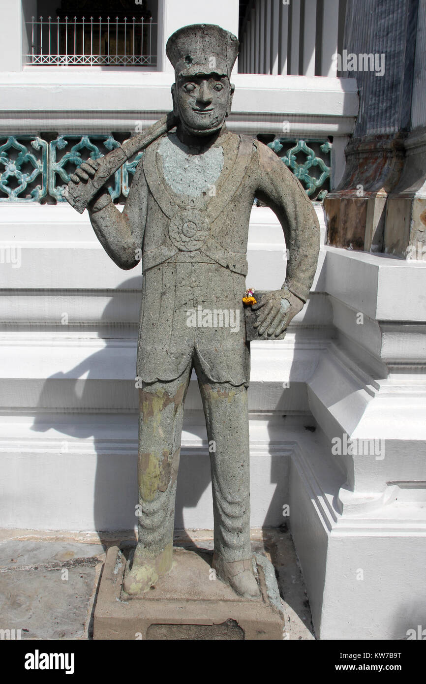 Cement sculpture of man near white temple in wat Suthat, Bangkok ...