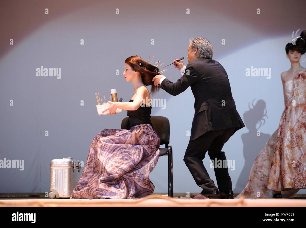 Hairdresser doing woman’s hair on a stage. Festival of hairdressing art ...