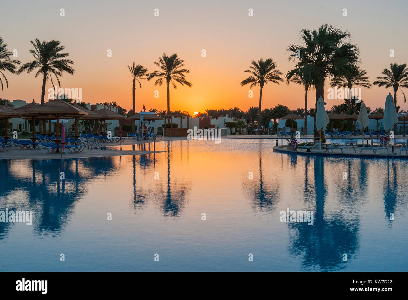 Large swimming pool in a luxury tropical hotel resort at dawn sunrise ...