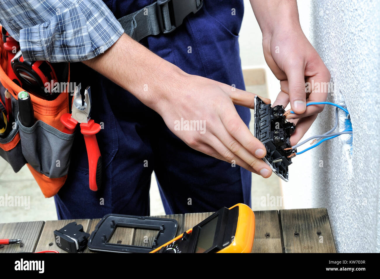 Young electrician at work on switches and sockets of a residential ...