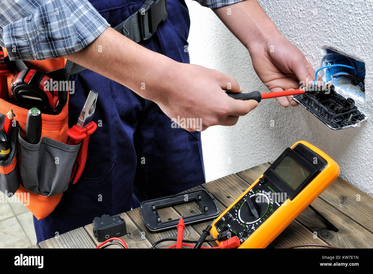 Young electrician at work on switches and sockets of a residential ...