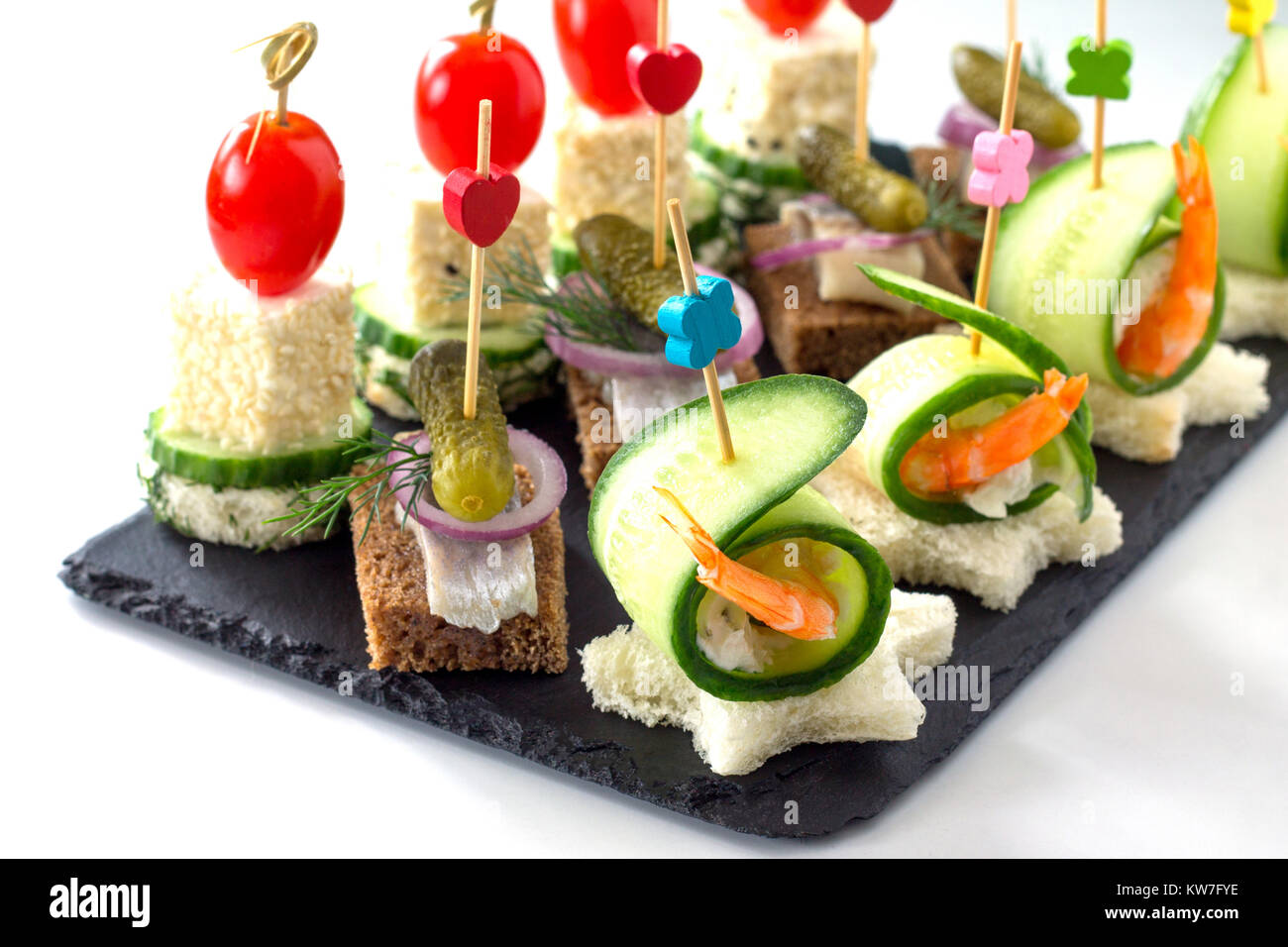 Snack canape with prawns, feta cheese and herring on rye bread on a ...