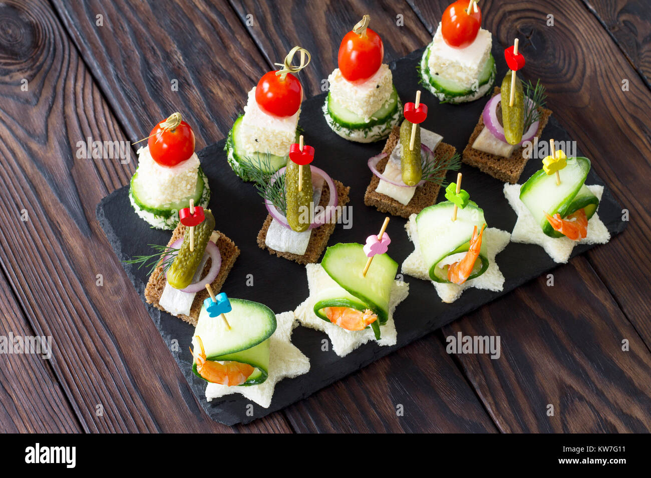 Canape with royal prawns, raw feta and herring on black bread on a ...