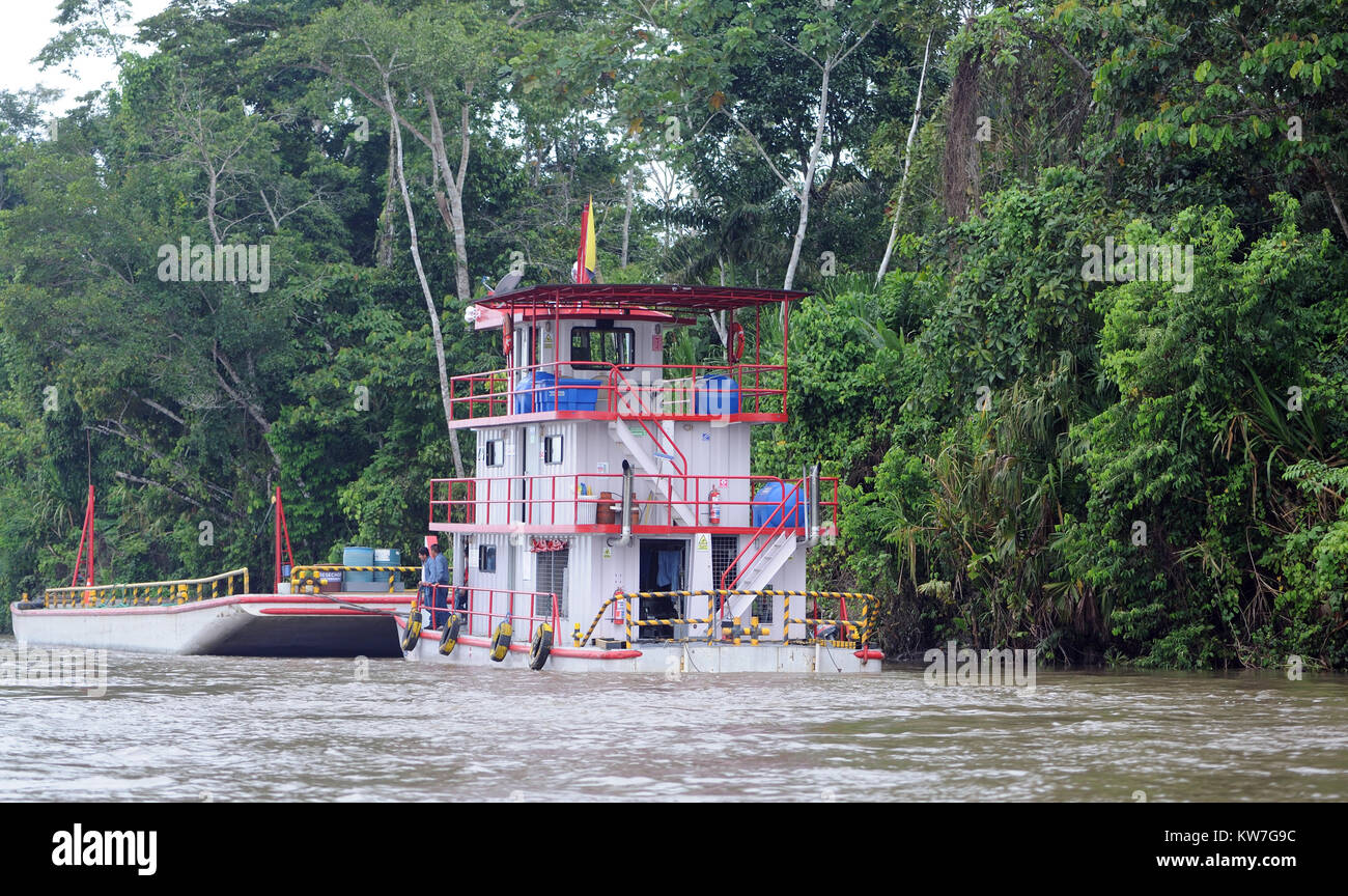 A three decked tug boat tows a barge past rain forest on the Napo River ... A three decked tug boat tows a barge past rain forest on the Napo River ...