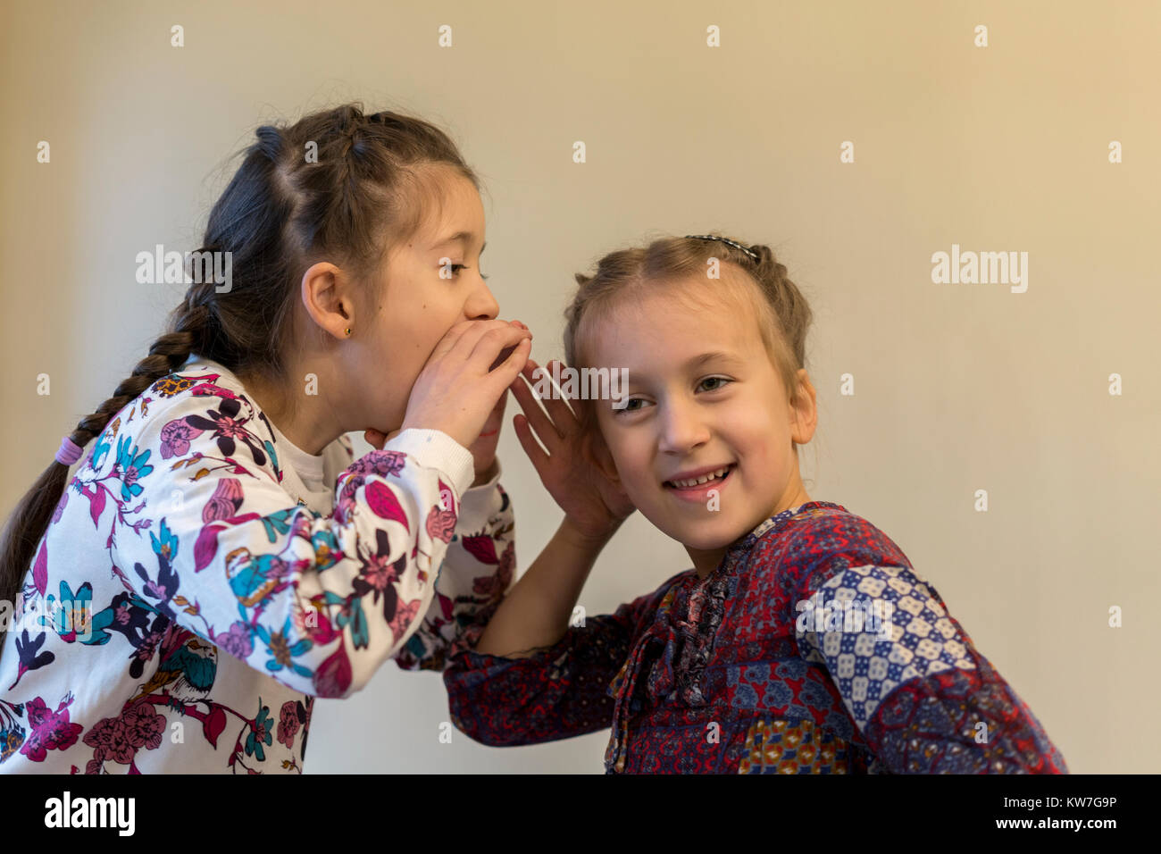 Young girl whispering secrets to her best friends ear Stock Photo - Alamy