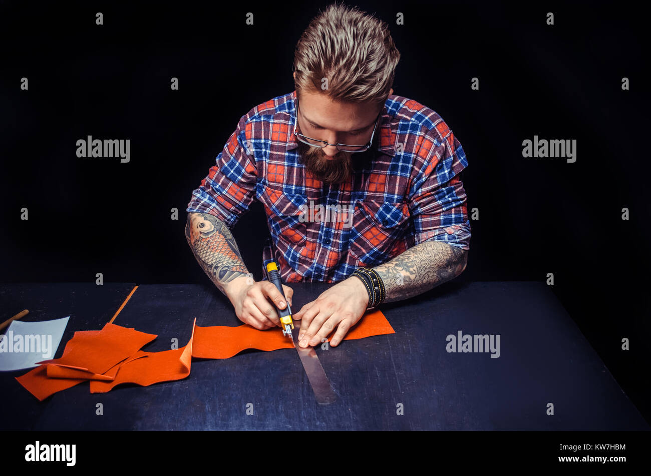 Craftsman demonstrates leather cutting process at workshop Stock Photo ...
