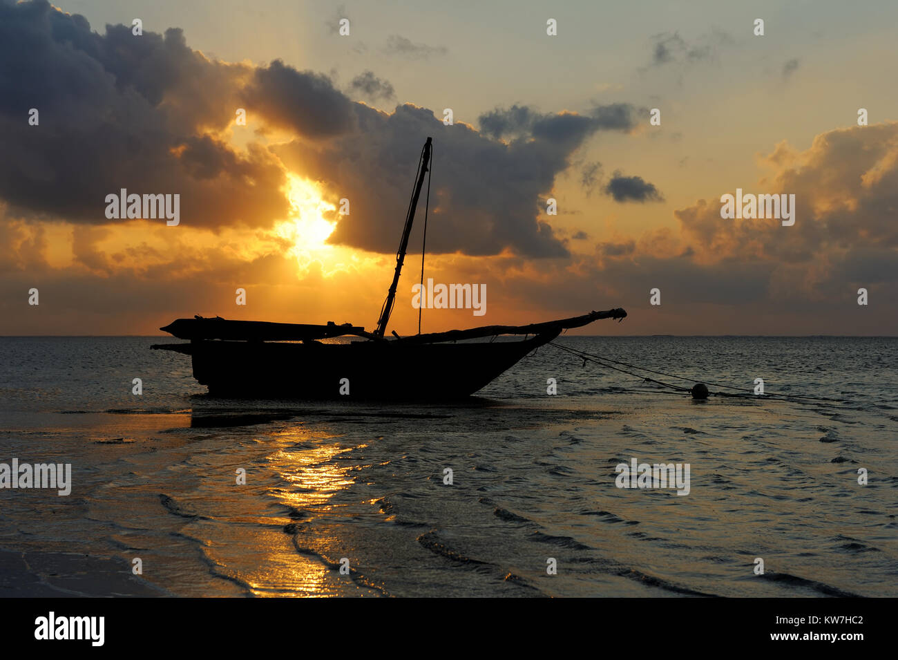 Beautiful tropical sunset with boat in ocean Stock Photo - Alamy