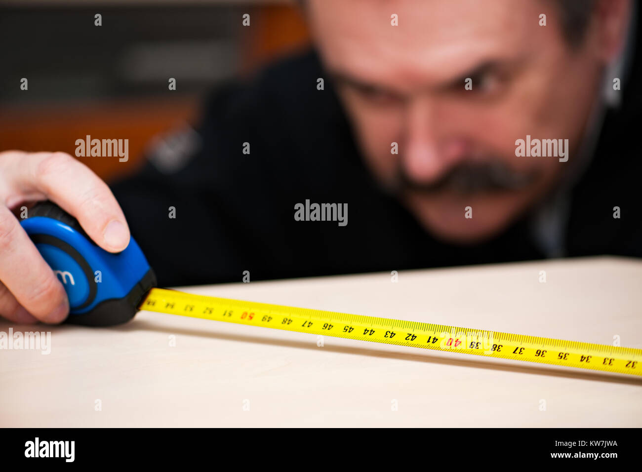 Man using tape measure Stock Photo - Alamy
