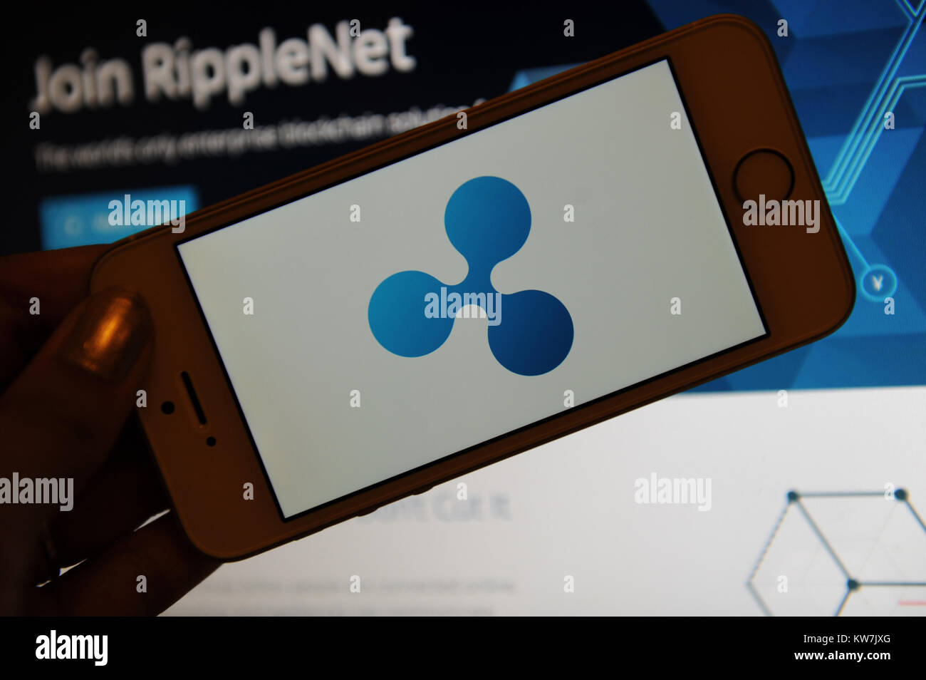 The Ripple logo is seen on a phone screen and RippleNet on a computer ...