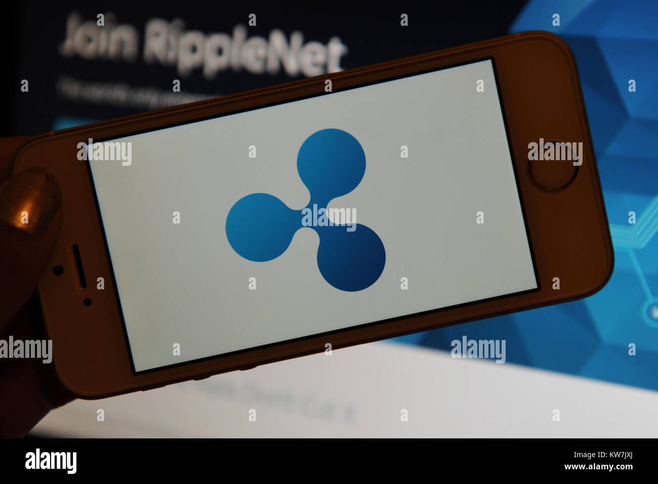 The Ripple logo is seen on a phone screen and RippleNet on a computer ...