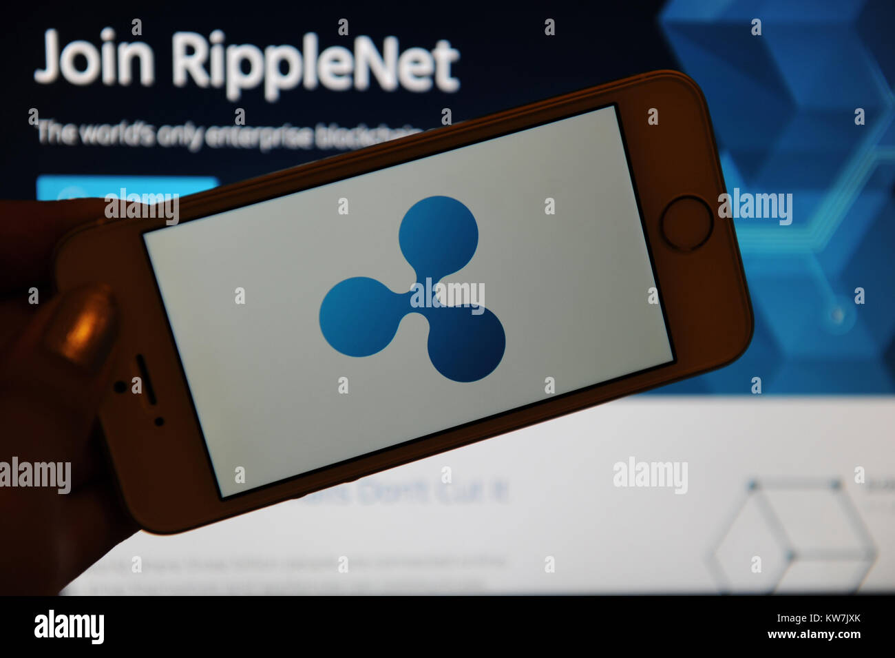 The Ripple logo is seen on a phone screen and RippleNet on a computer ...